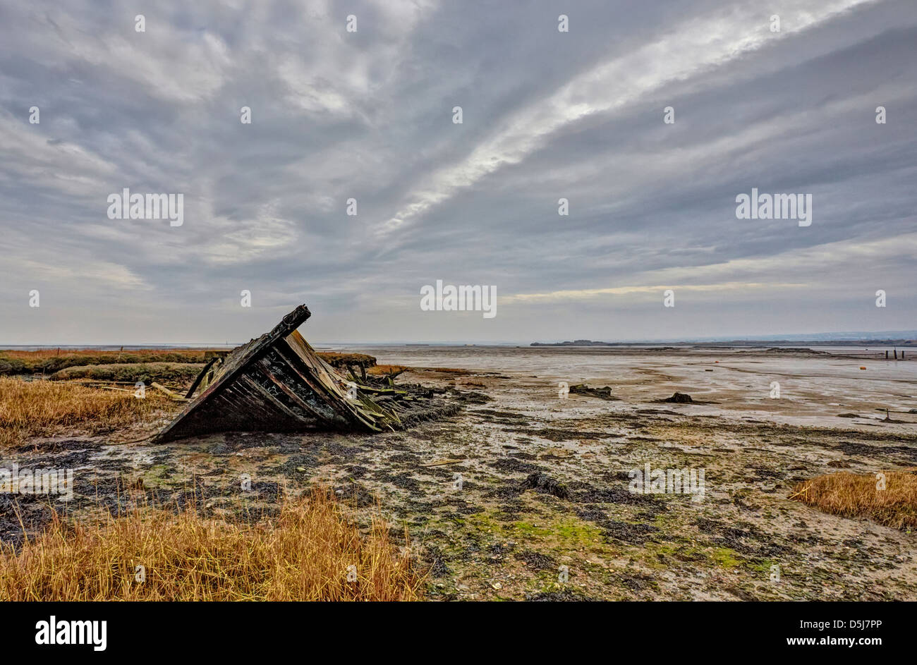 Hoo marshes with a derelict wooden boat looking out to the river Medway ...