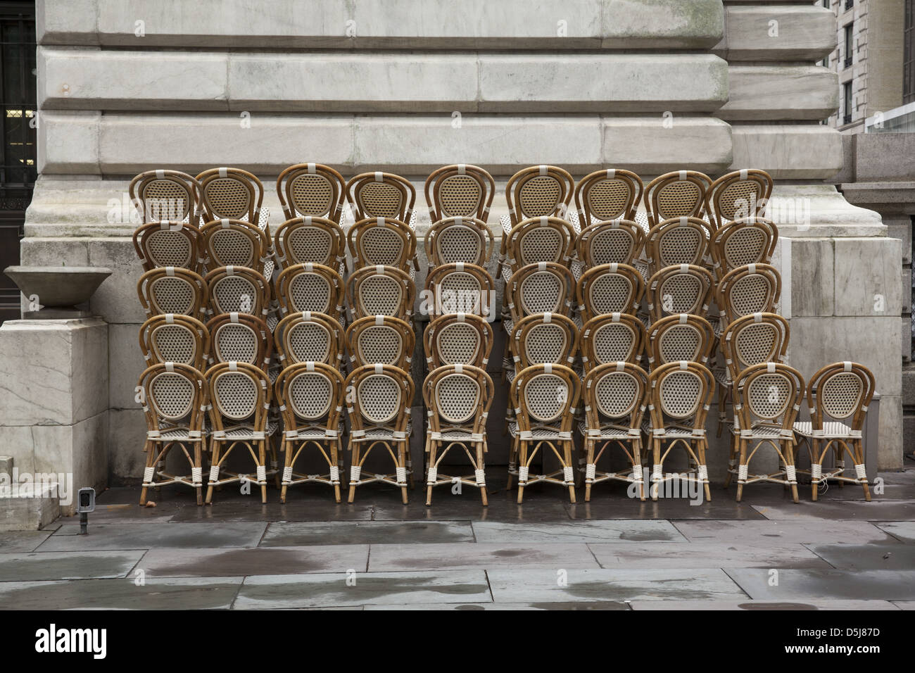 Stacked cafe chairs at Bryant Park behind the New York Public Library ...