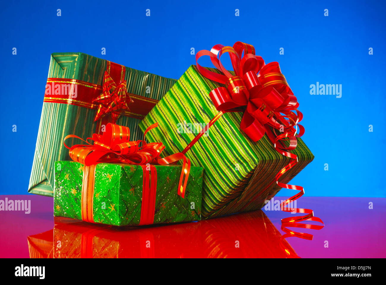 Three green presents against blue background Stock Photo - Alamy