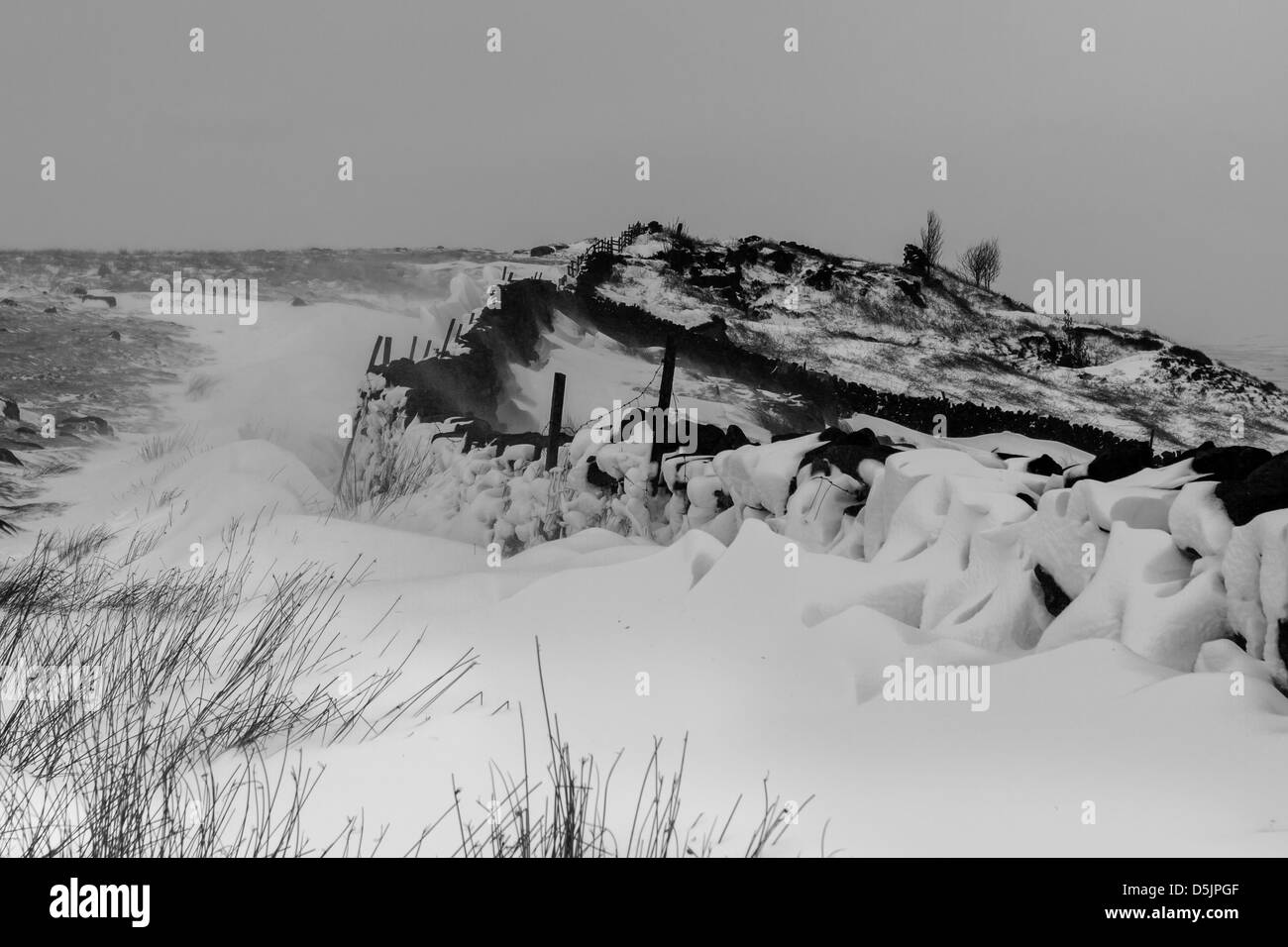 Countryside Winter landscape with stone wall and thick windswept snow ...