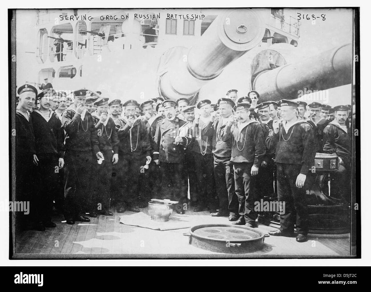 The photograph depicts a scene aboard a Russian battleship, showing ...