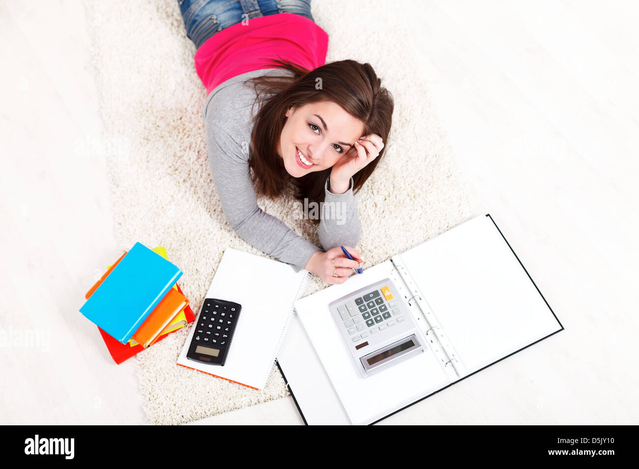 Pretty young woman lying on the floor and studying Stock Photo - Alamy