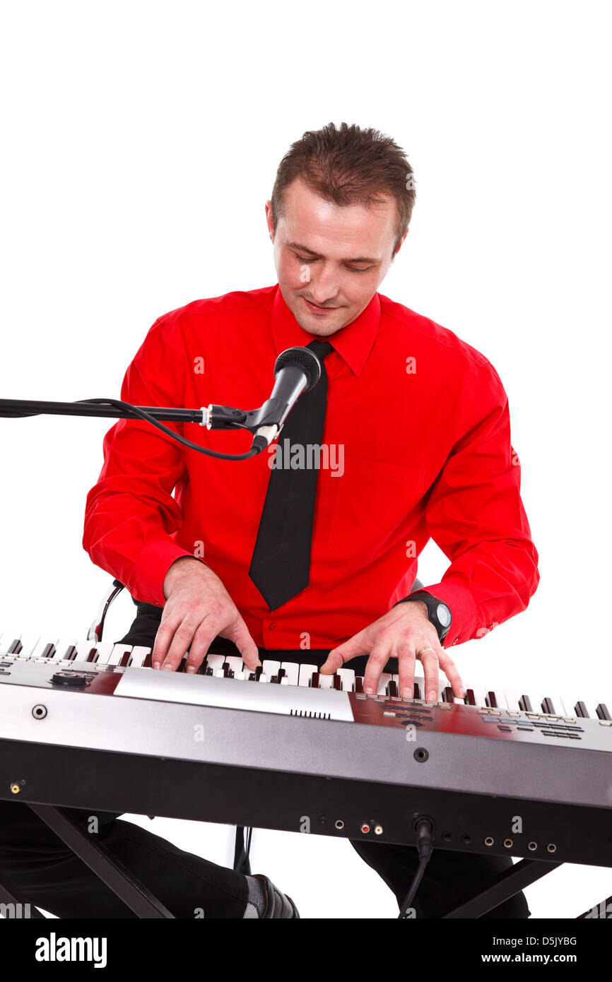 Synthesizer artist in red shirt playing on keyboard behind microphone ...