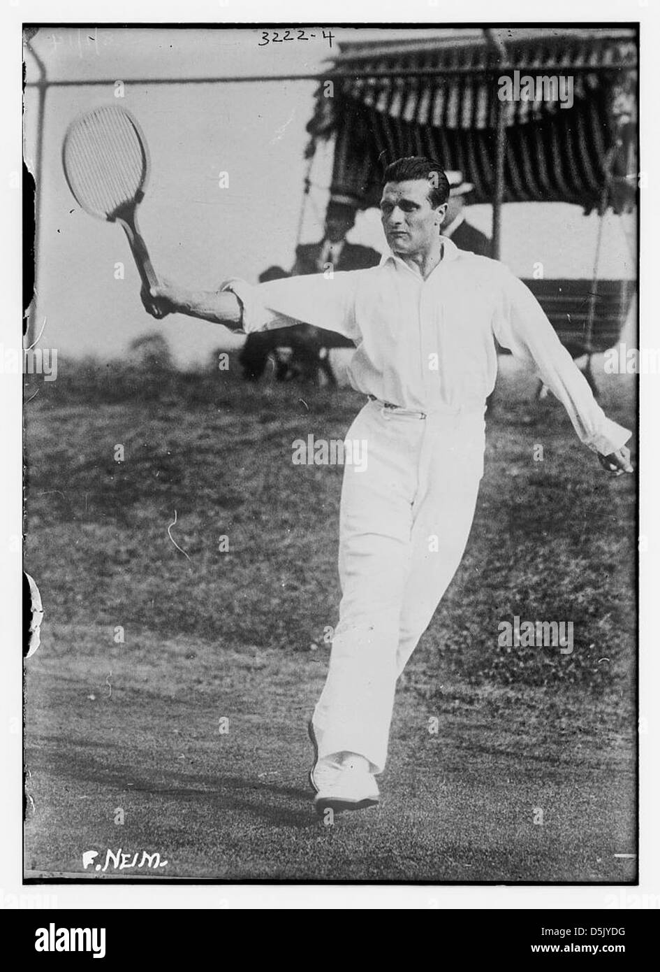 A photograph of a man named F. Neim playing tennis outdoors, captured ...