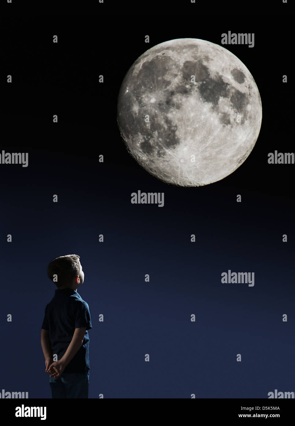 Boy (4-5) looking at full moon Stock Photo - Alamy