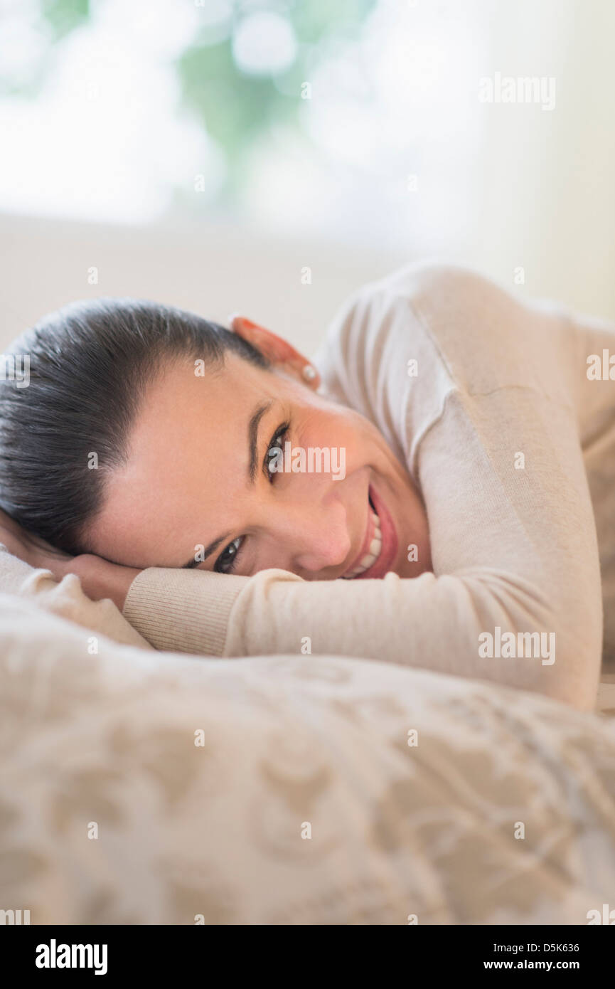 Portrait of woman lying on bed Stock Photo - Alamy