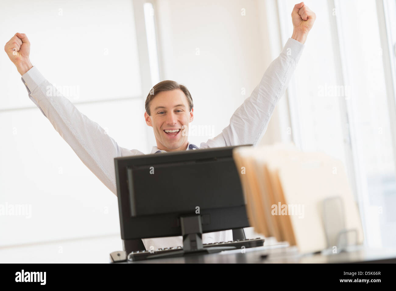 Office worker cheering in front of computer Stock Photo - Alamy