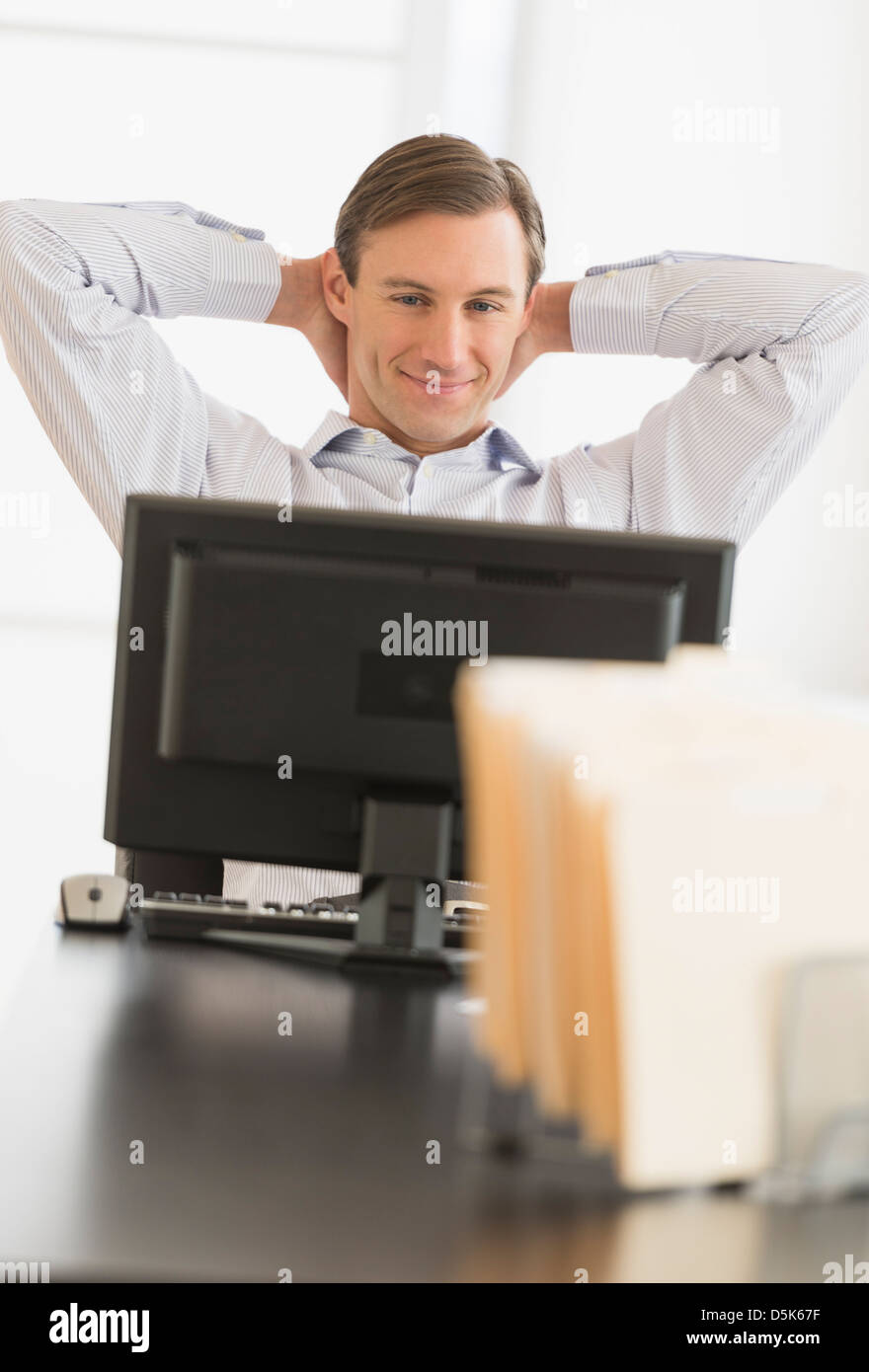 Office worker relaxing in front of computer Stock Photo - Alamy