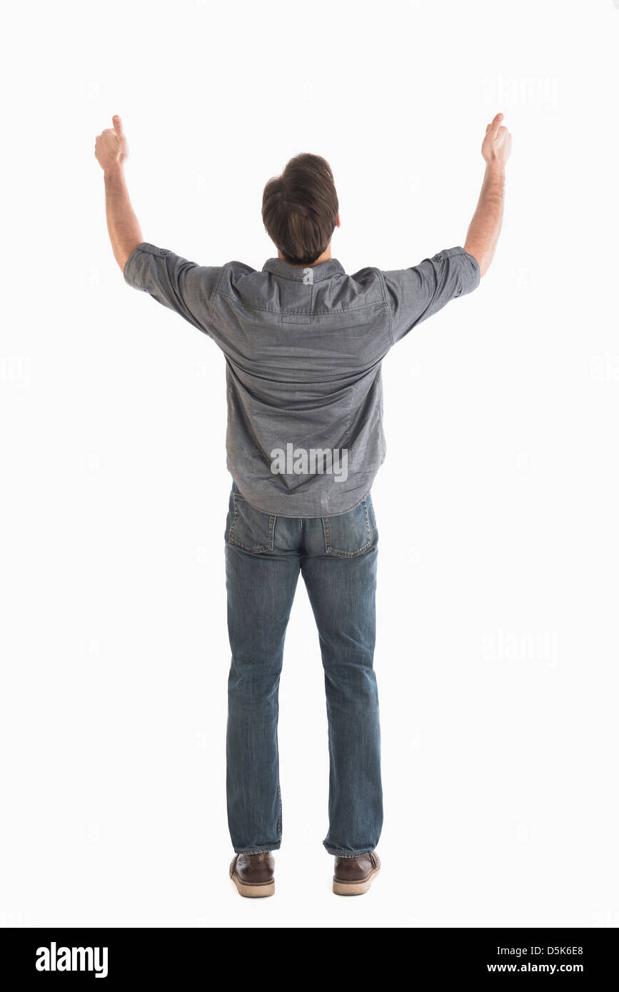 Rear view of man raising arms Stock Photo - Alamy