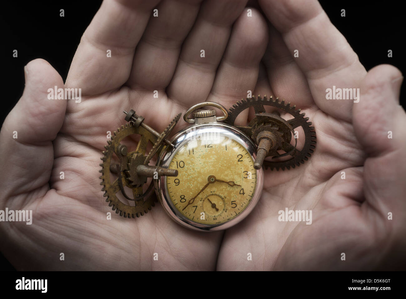 Hands holding antique clock and gears Stock Photo - Alamy