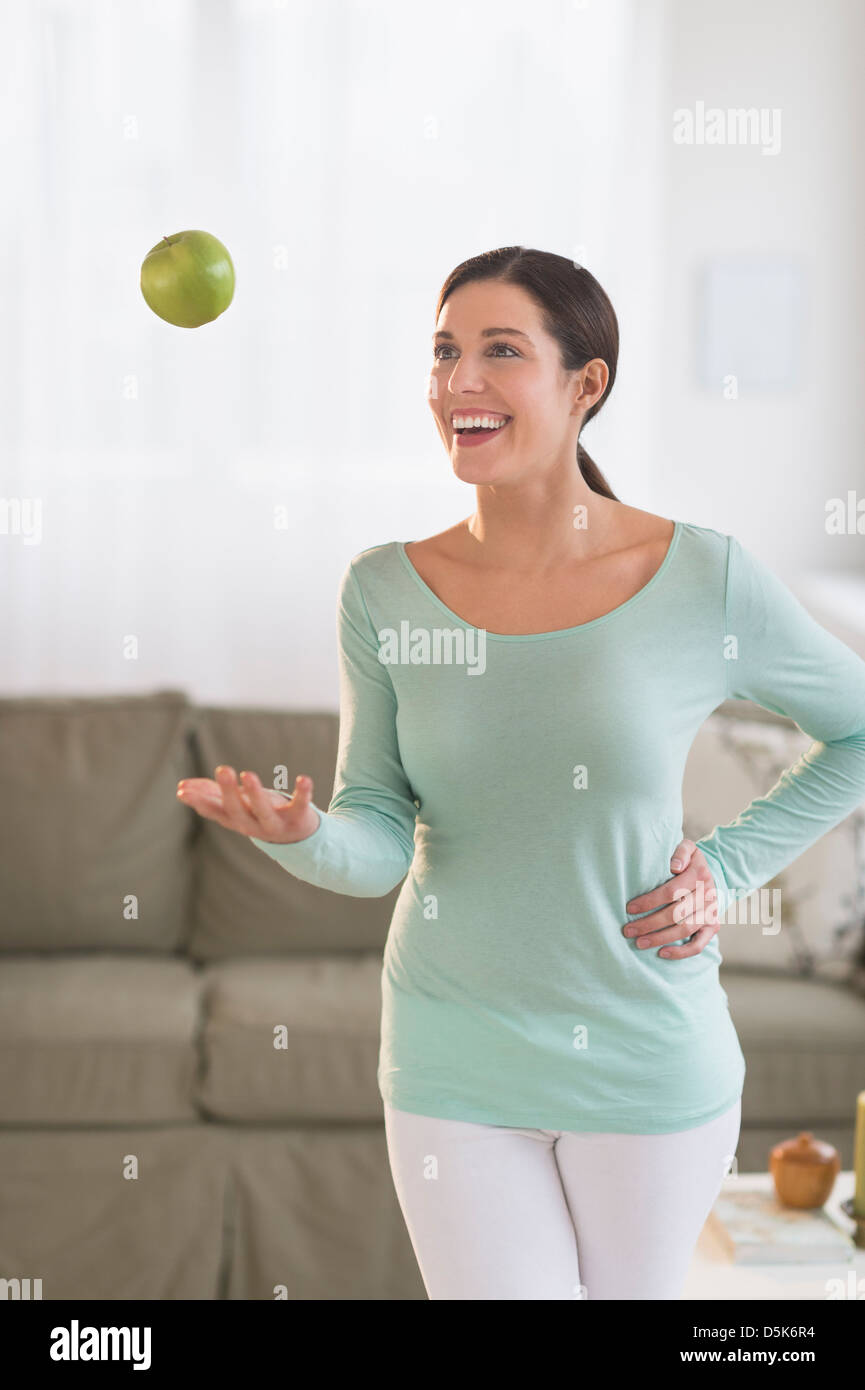 Woman juggling with apple at home Stock Photo - Alamy
