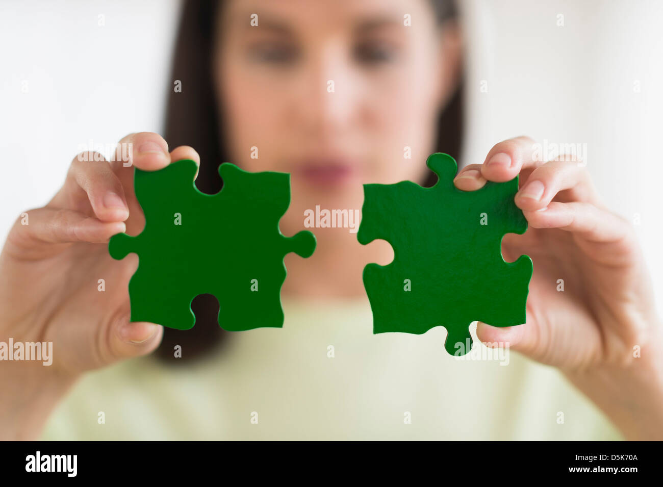Woman holding green puzzle pieces Stock Photo - Alamy