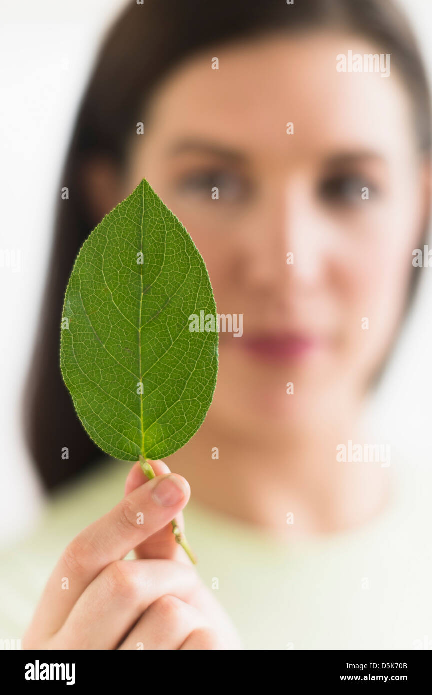 Woman holding green leaf Stock Photo - Alamy