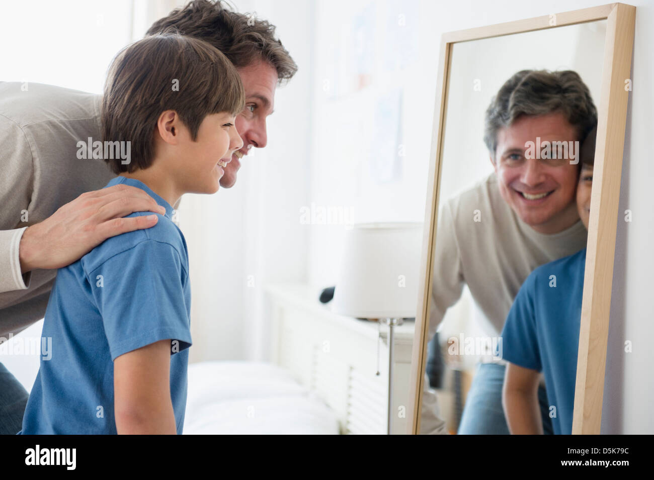 Father and son (8-9) looking into mirror Stock Photo - Alamy