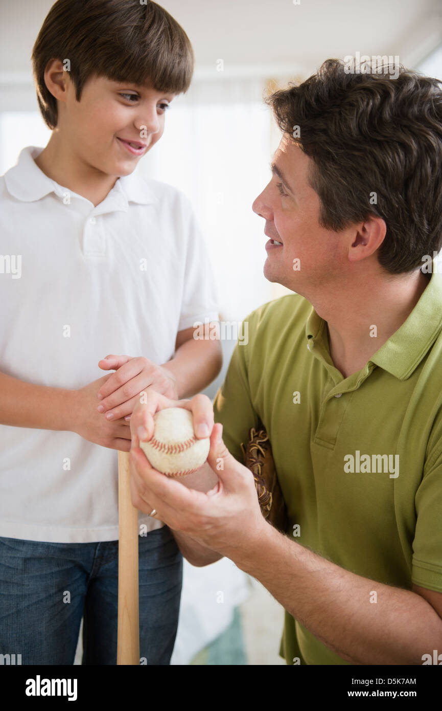 Father explain son (8-9) how to play baseball Stock Photo - Alamy
