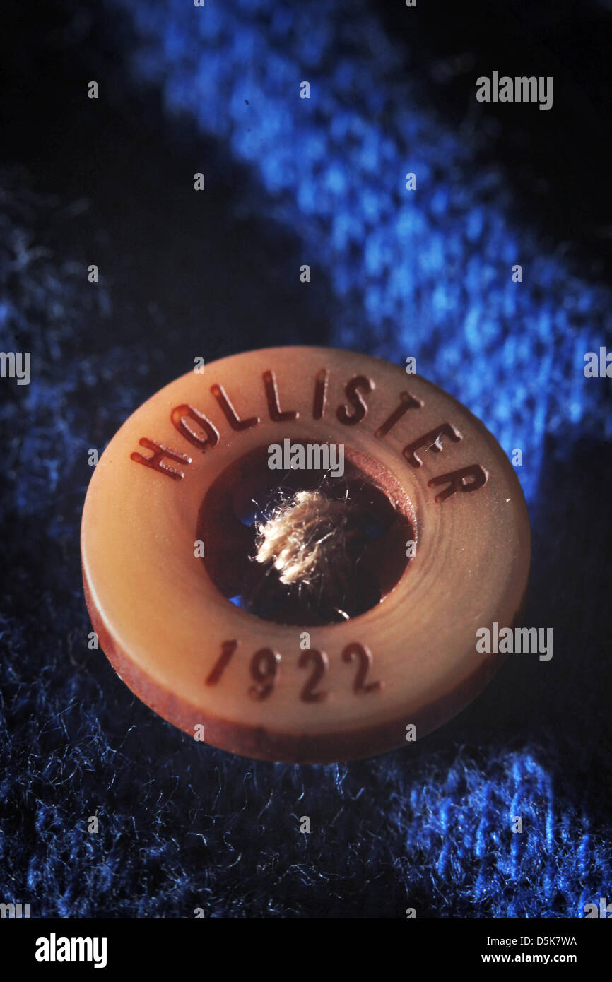 A button with the stamped in logo of US fashion label Hollister is ...
