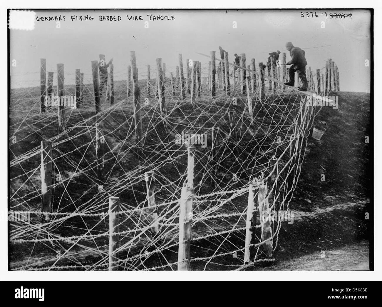 A photograph showing German soldiers fixing a tangled barbed wire ...