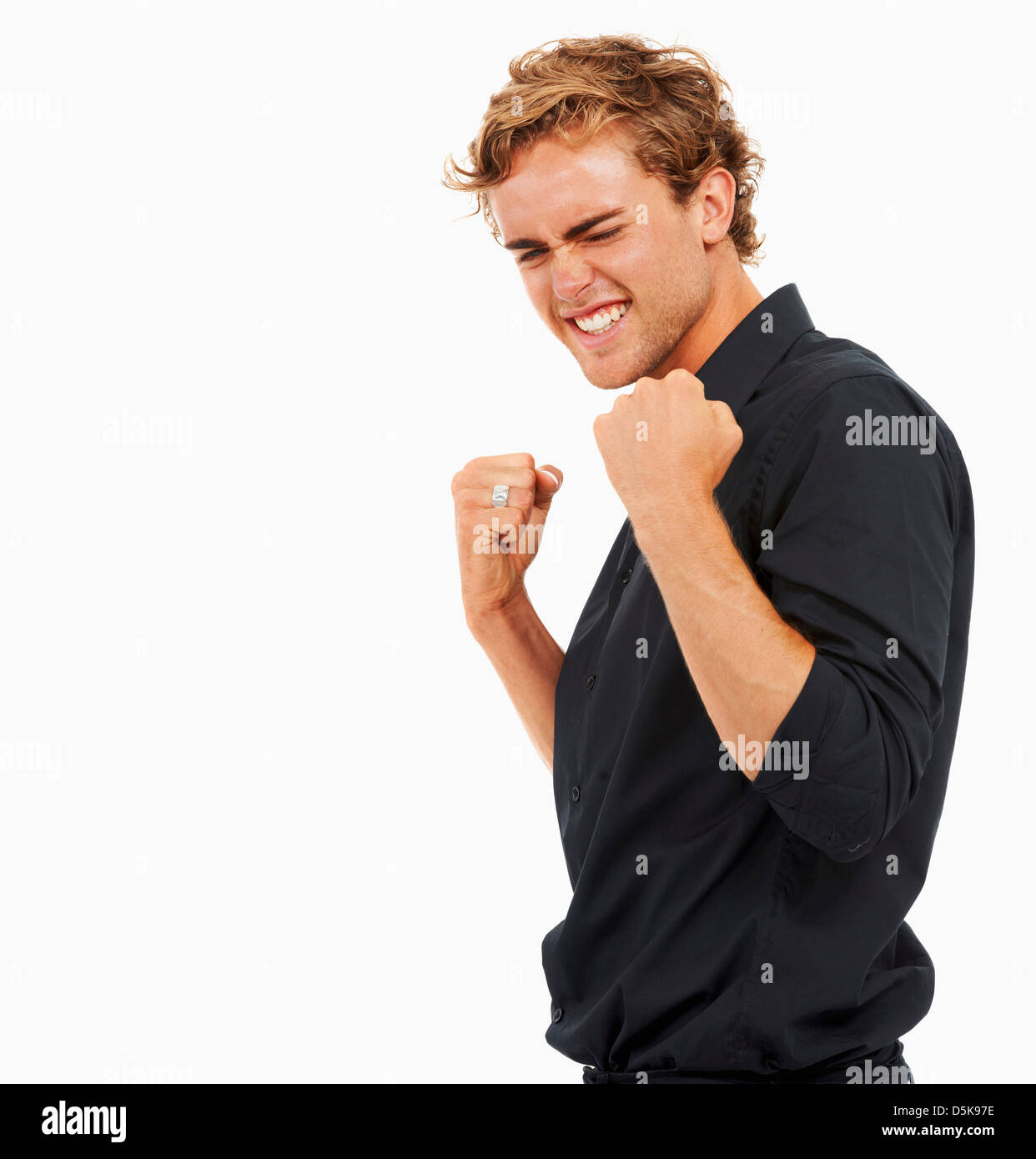 Studio Shot, Portrait of young man with arms raised and clenched fists ...