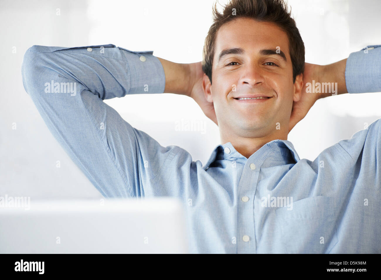 Hands behind head man shirt hi-res stock photography and images - Alamy