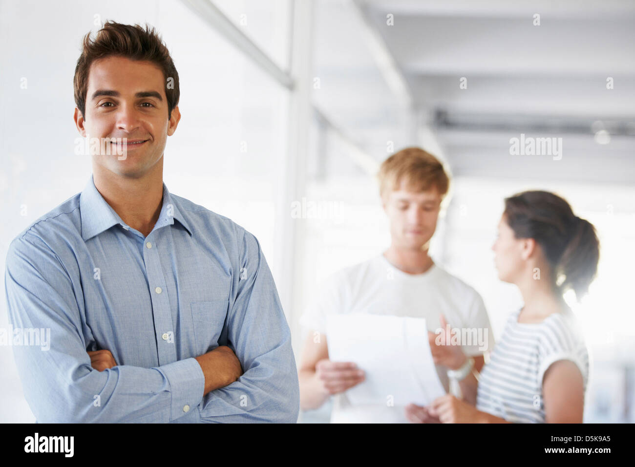 Portrait of man with coworkers in background Stock Photo - Alamy
