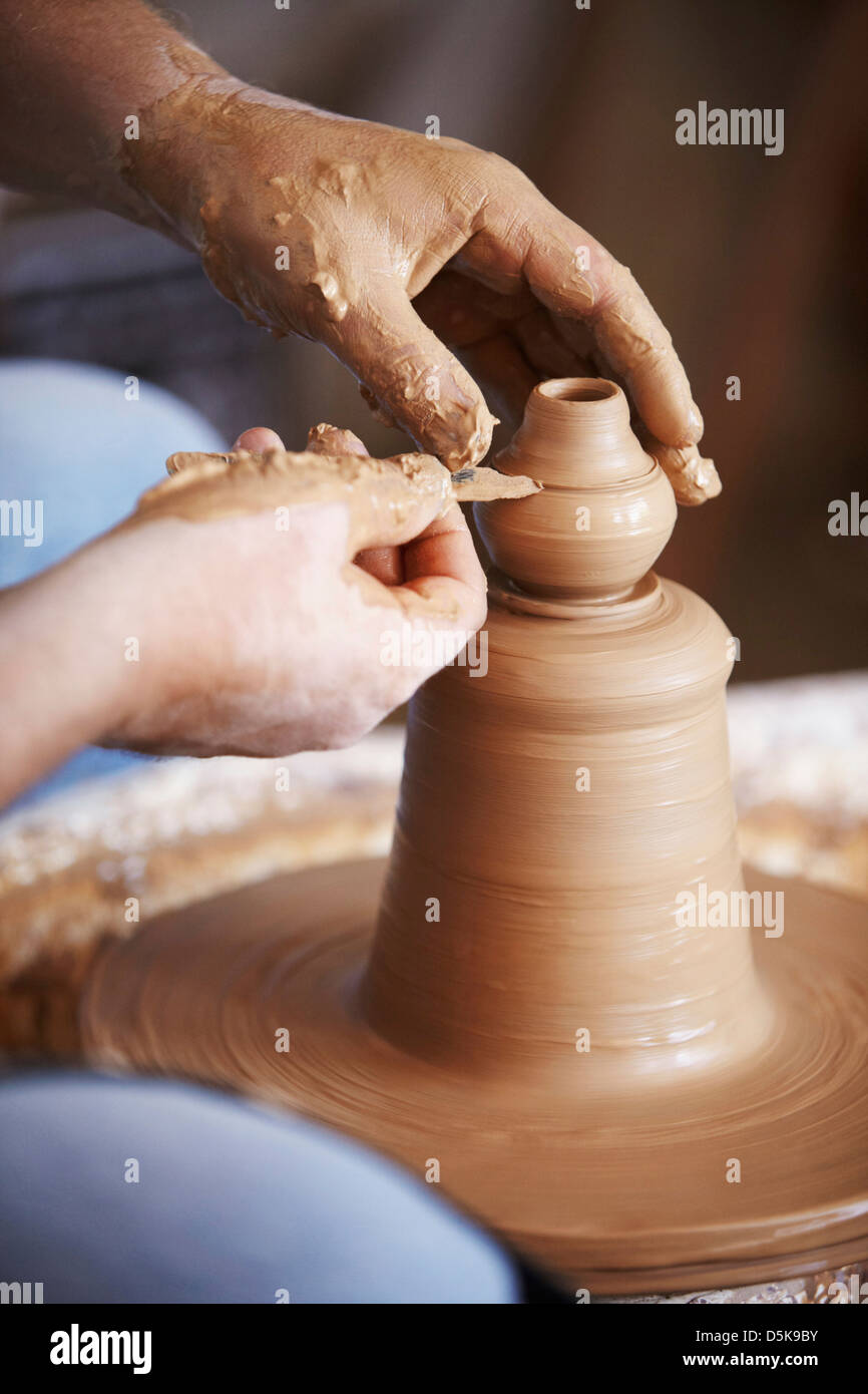 Hands working with clay on potter's wheel Stock Photo - Alamy