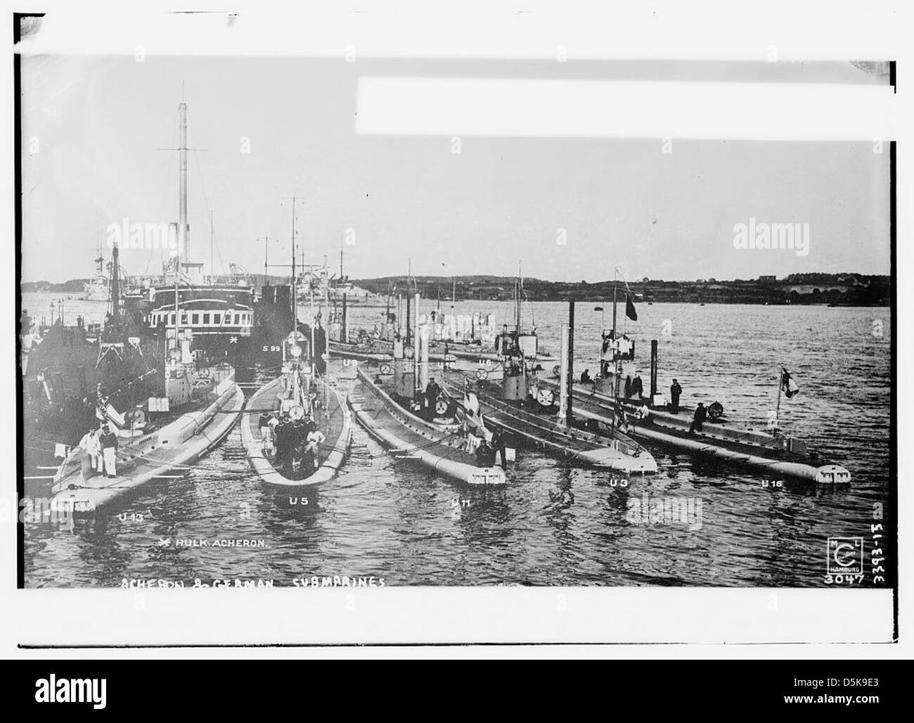 A photograph showing the Acheron and German submarines, likely captured ...