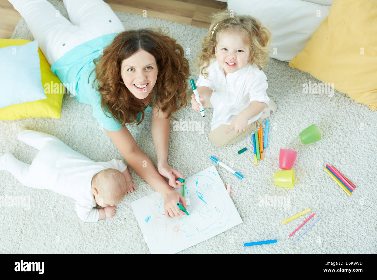 The above-view portrait of a beautiful babysitter looking after cute ...
