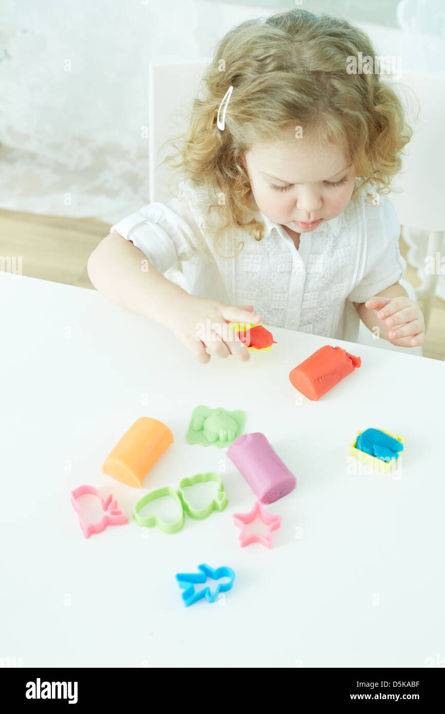 Young girl playing with modeling clay hi-res stock photography and ...