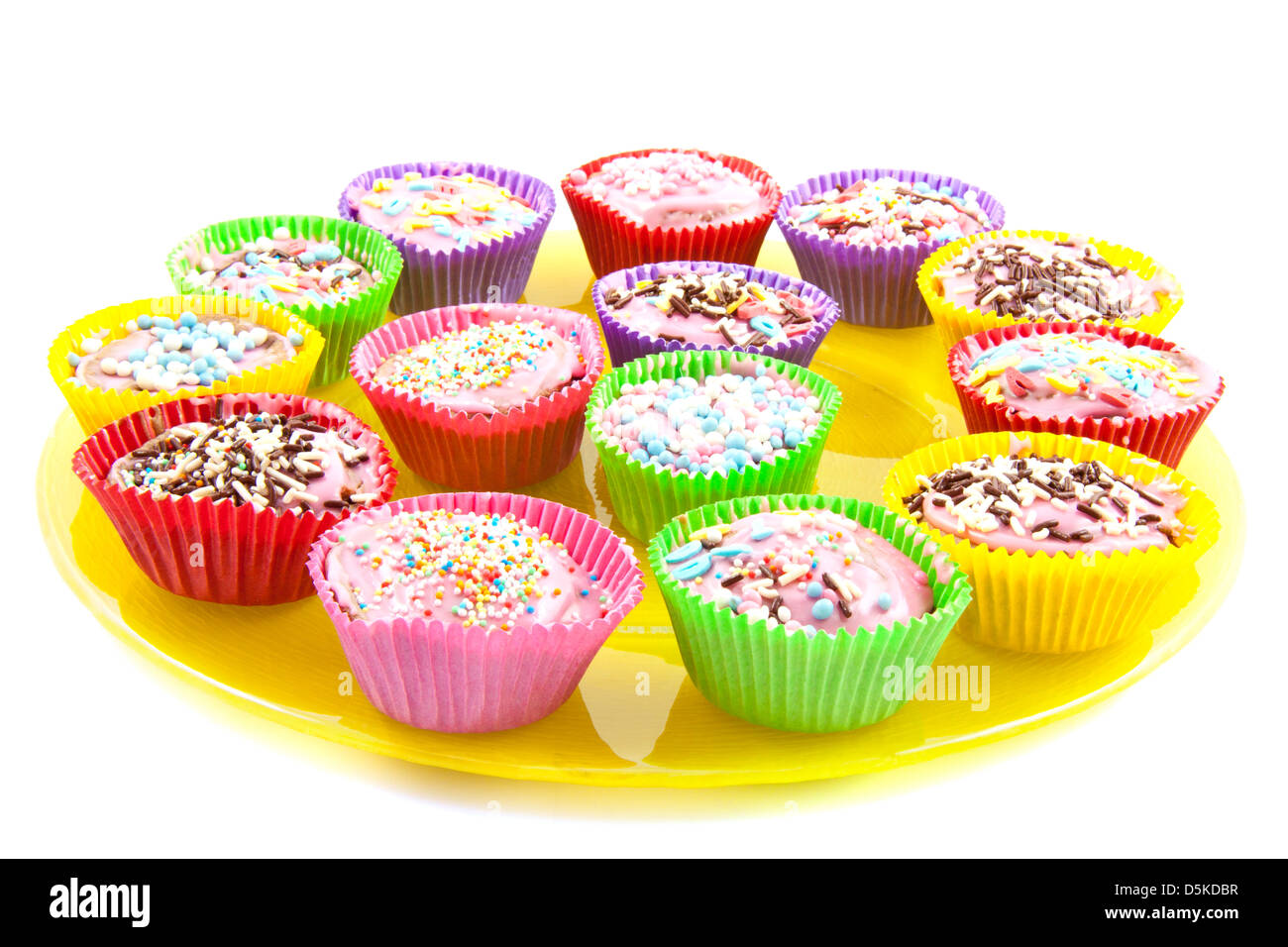 Different kind of cup cakes on a decorated glass plate isolated over ...