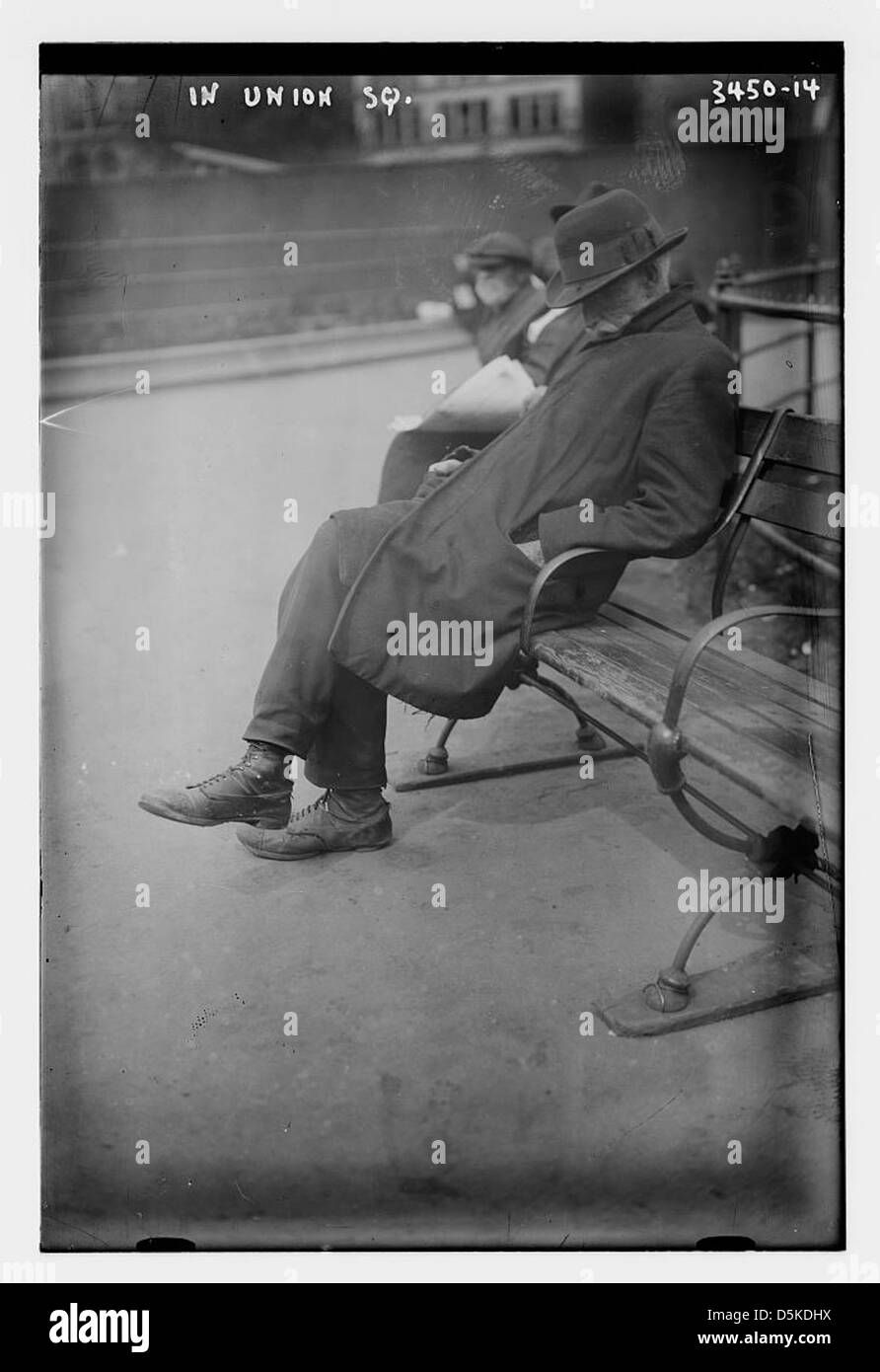 This photograph shows a man resting on a park bench in Union Square ...