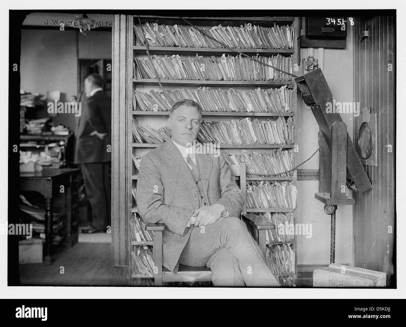 This photograph shows J. Walter Smith seated in an office, surrounded ...
