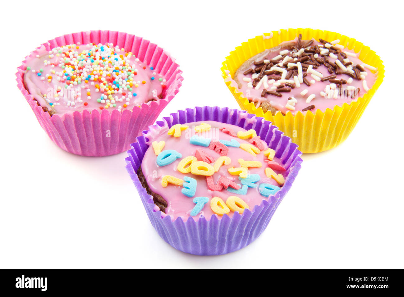 Three colorful decorated cupcakes isolated over white Stock Photo - Alamy