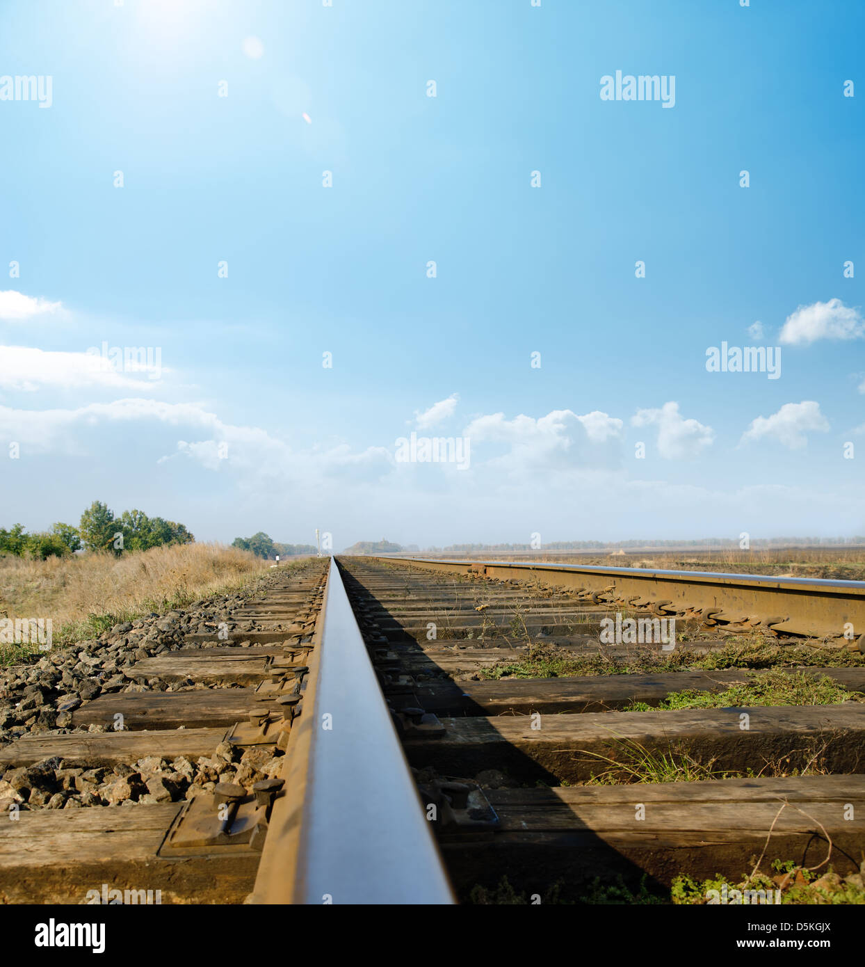 railway to horizon under sunny sky Stock Photo - Alamy