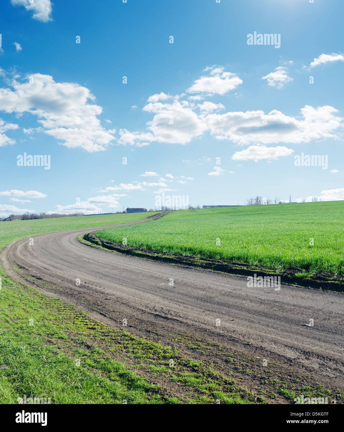 winding rural road under blue cloudy sky Stock Photo - Alamy