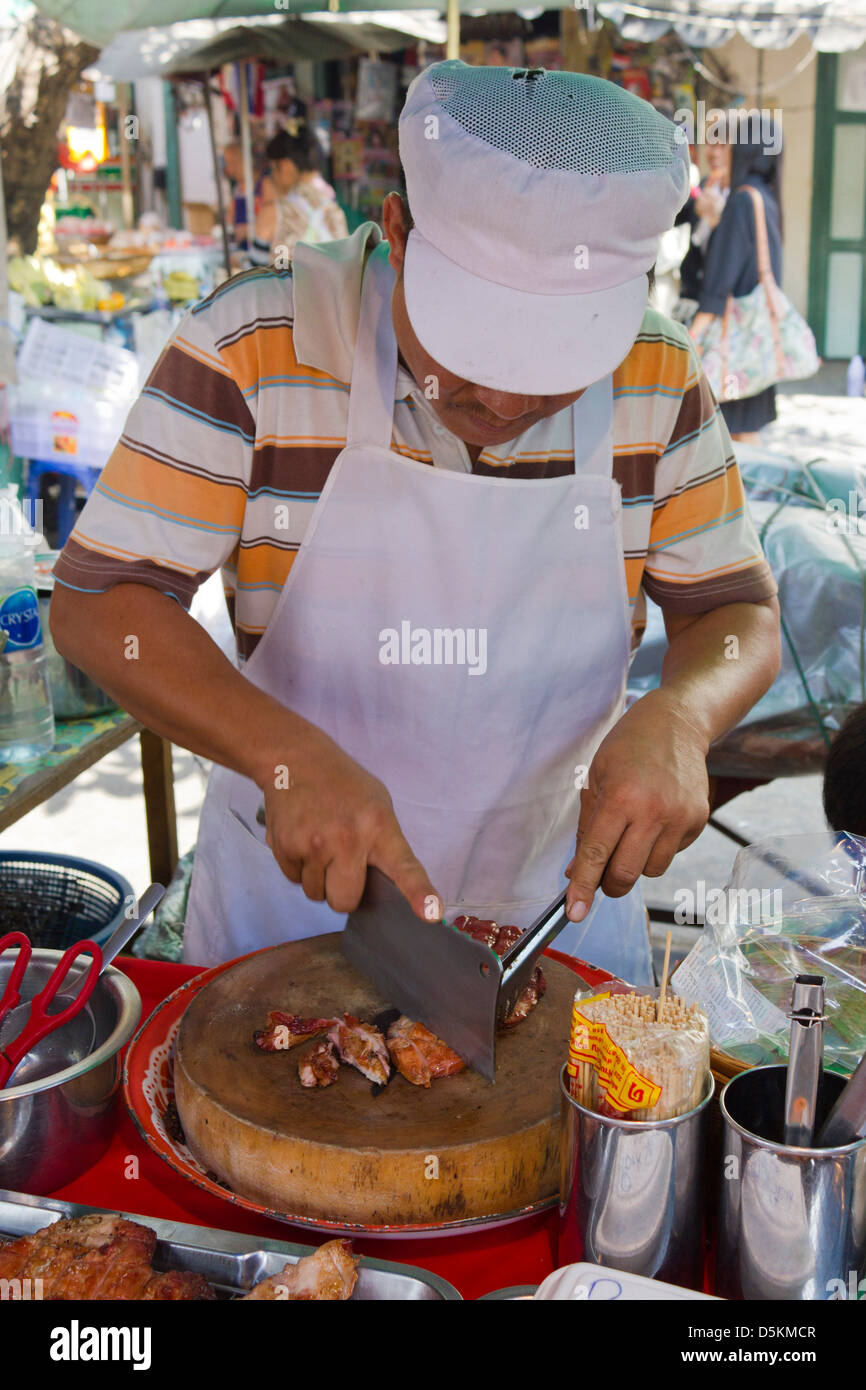 A food stall on the street in Bangkok. A large pot with the lid propped ...
