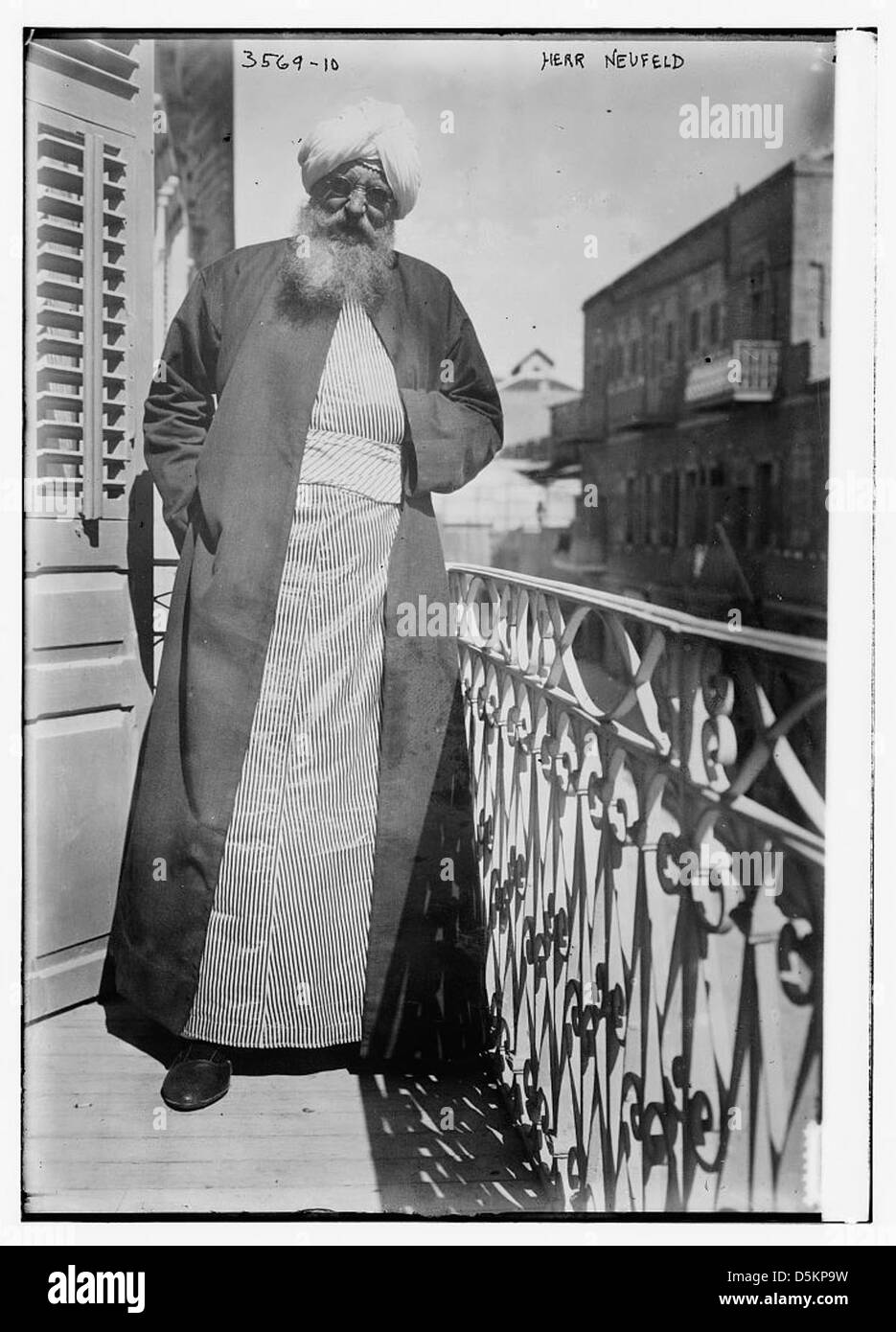 A portrait of Herr Neufeld, a man with a full beard and wearing glasses ...