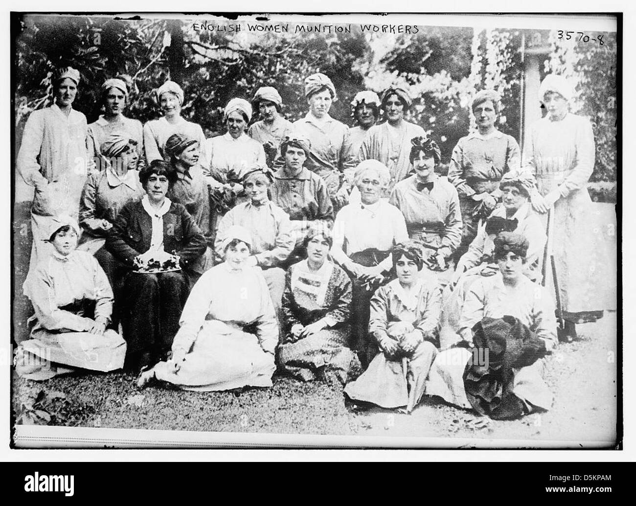 The photograph shows a group of English women working in munitions ...