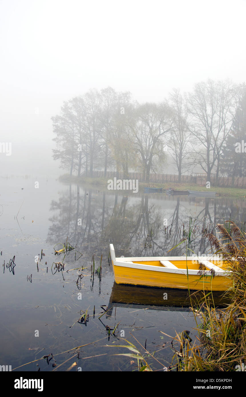 autumn lake landscape with yellow boat and morning mist Stock Photo - Alamy