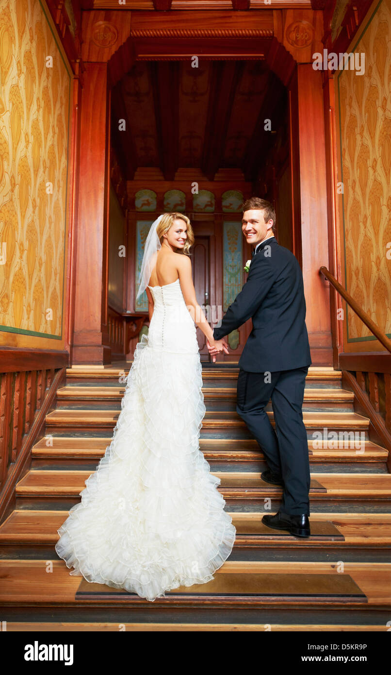 Young couple standing on steps in hallway Stock Photo - Alamy