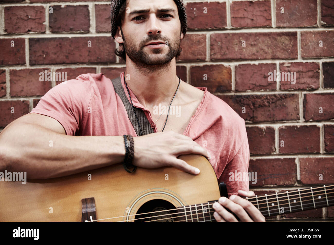 Portrait of musician against brick wall Stock Photo - Alamy
