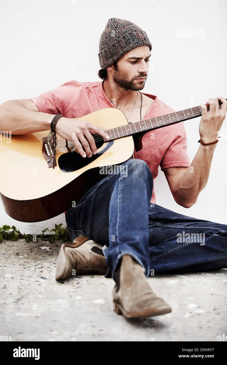Musician playing guitar outdoors Stock Photo - Alamy
