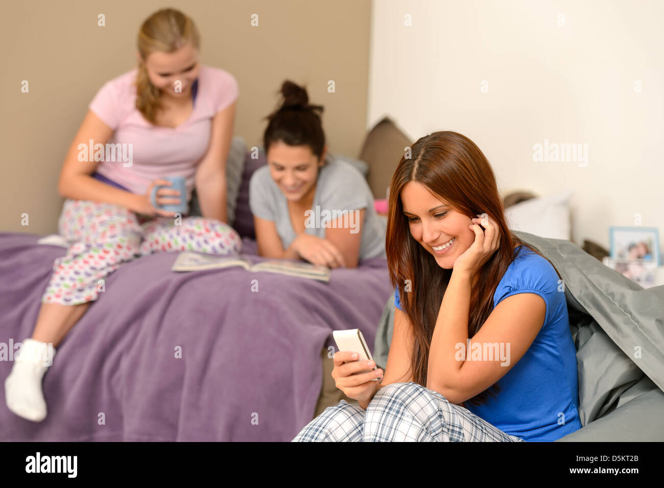 Smiling teenager girl sending text message at pajama party Stock Photo ... Smiling teenager girl sending text message at pajama party Stock Photo ...