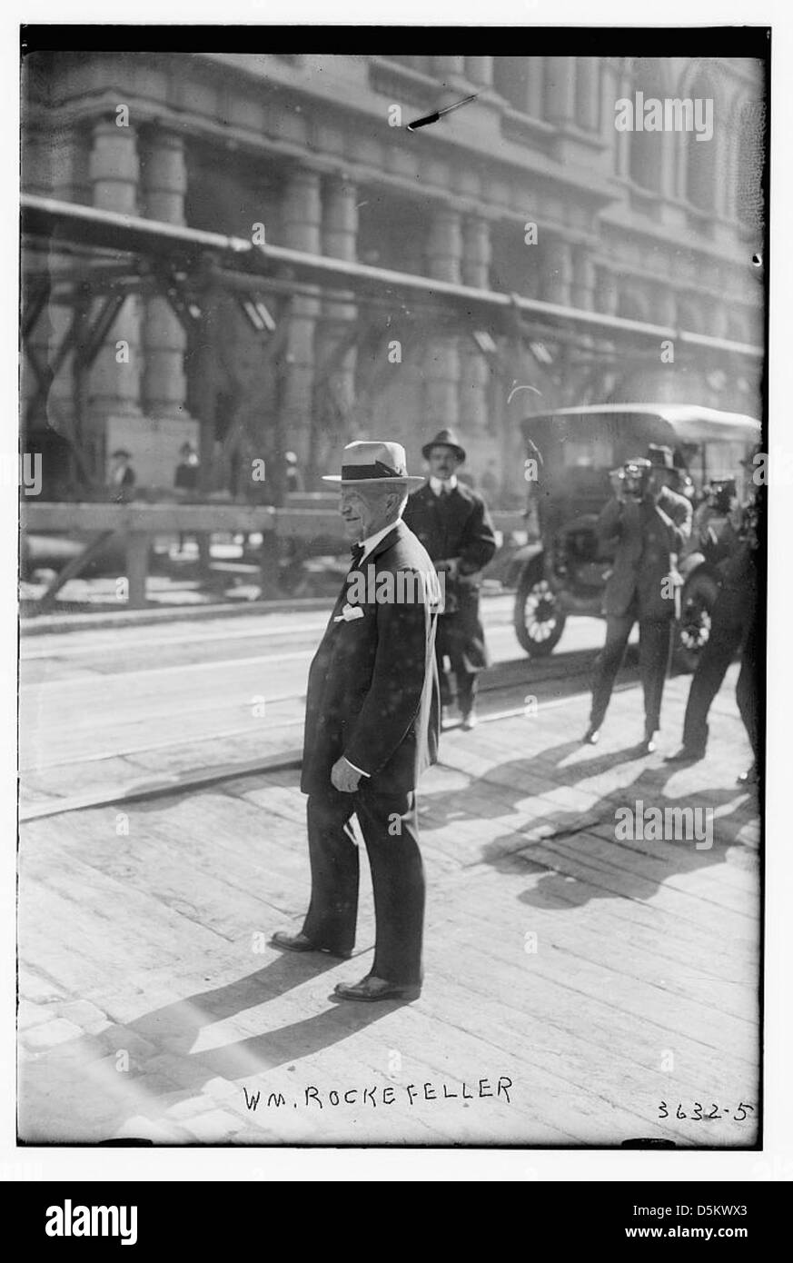 A photograph of William Rockefeller, standing outdoors with a camera ...
