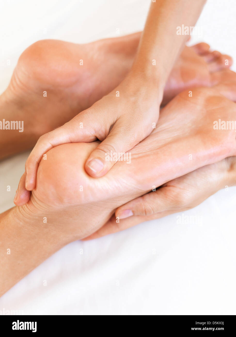 Hand massaging feet Stock Photo - Alamy