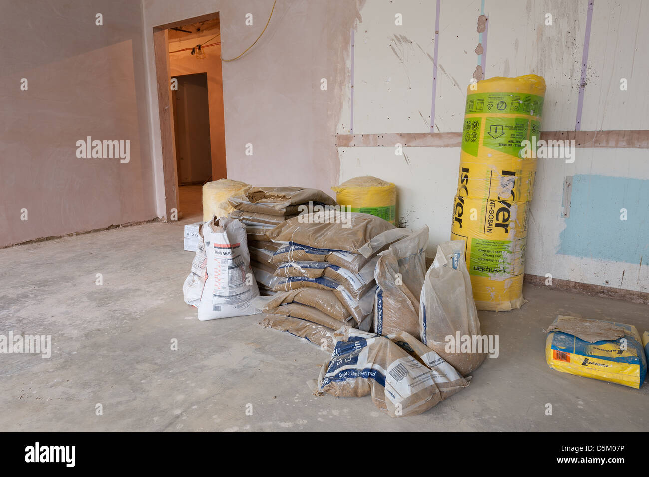 Bags of cement plaster rockwool insulation piled up inside a newly ...