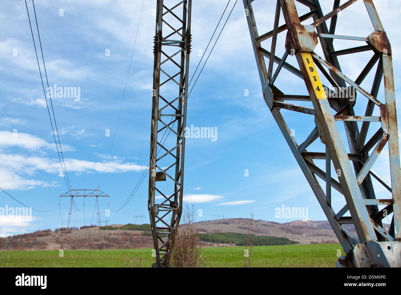 Steel lattice high voltage transmission towers in a green field under ...