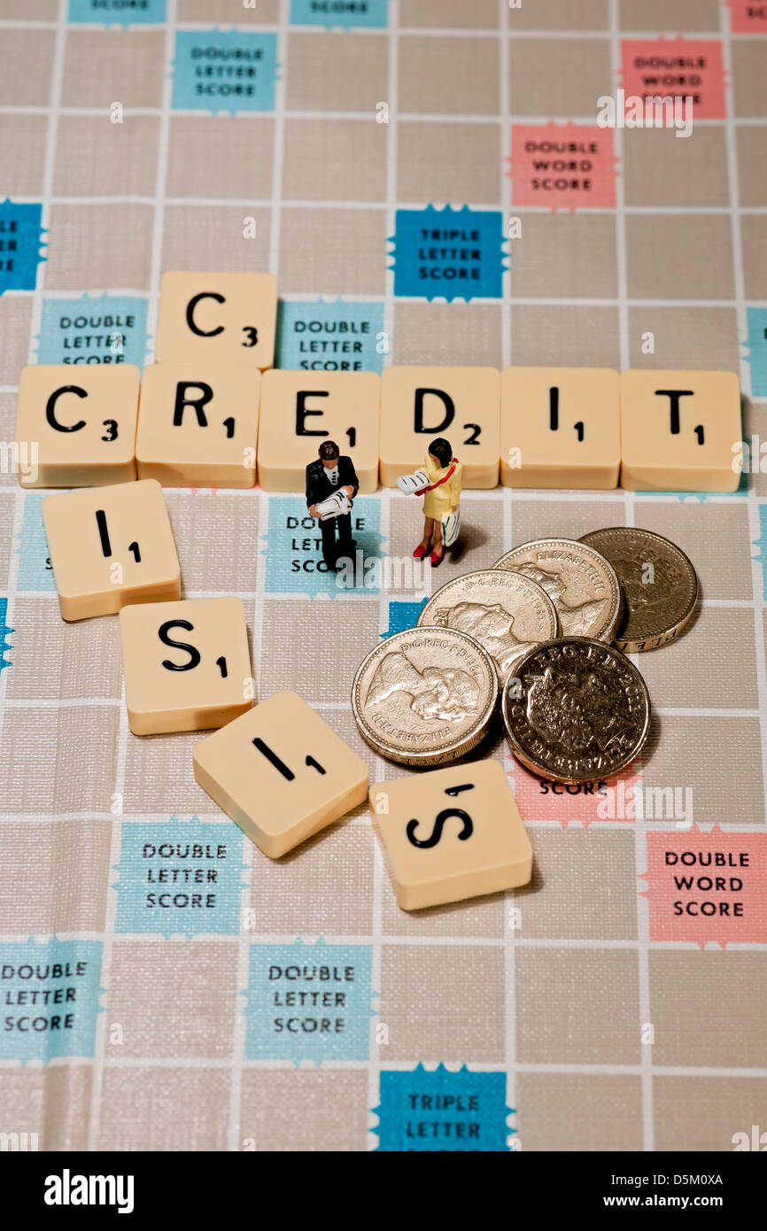 Tiles on Scrabble board words spelling credit crisis, with toy man and ...