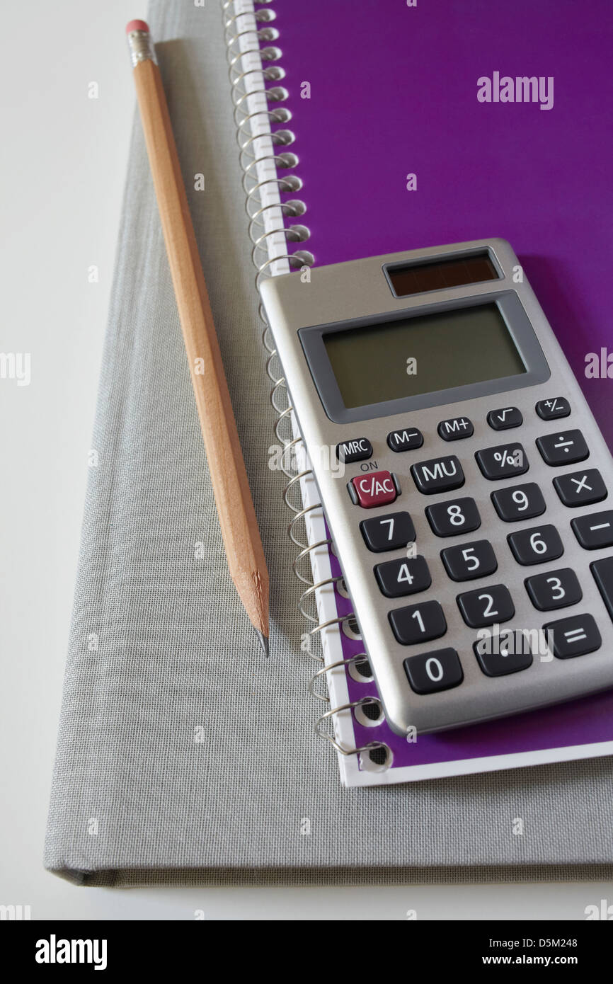 Calculator, textbook, pencil and notebook, studio shot Stock Photo - Alamy