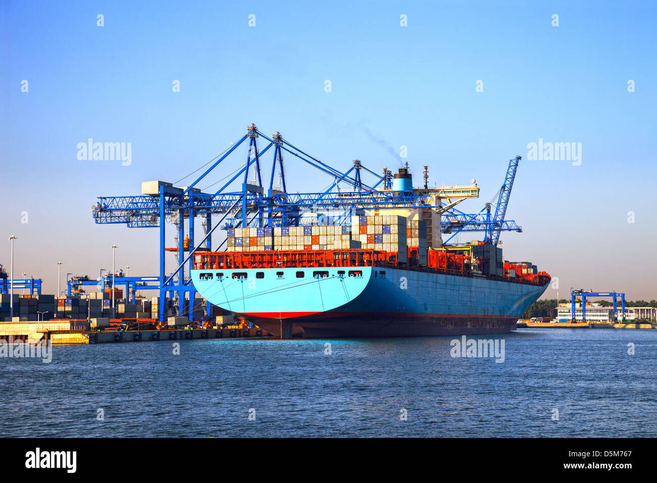 Big port cranes and a Container Ship Stock Photo - Alamy