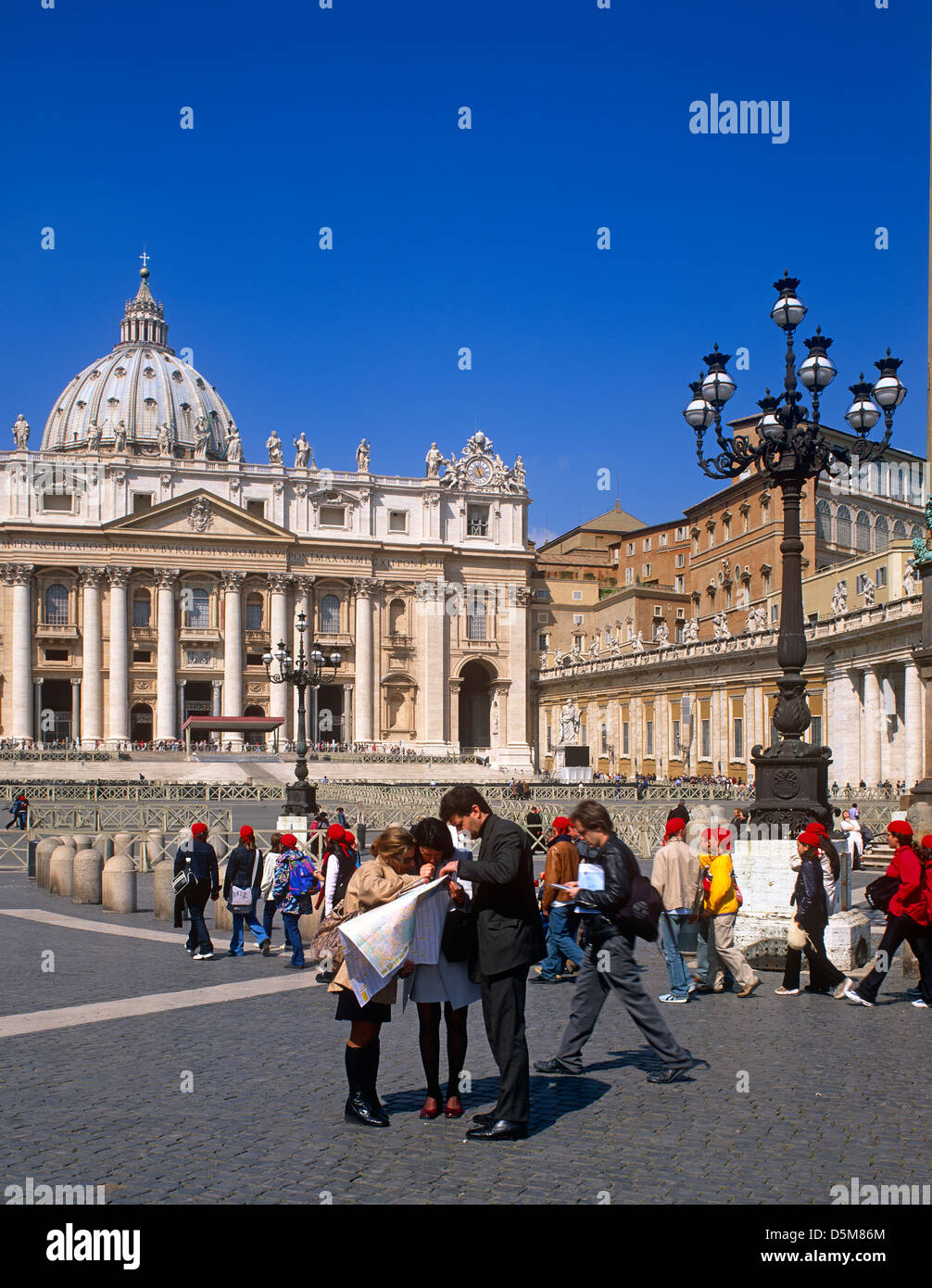 Tourists in St Peter's Square, the Basilica is in the background ...